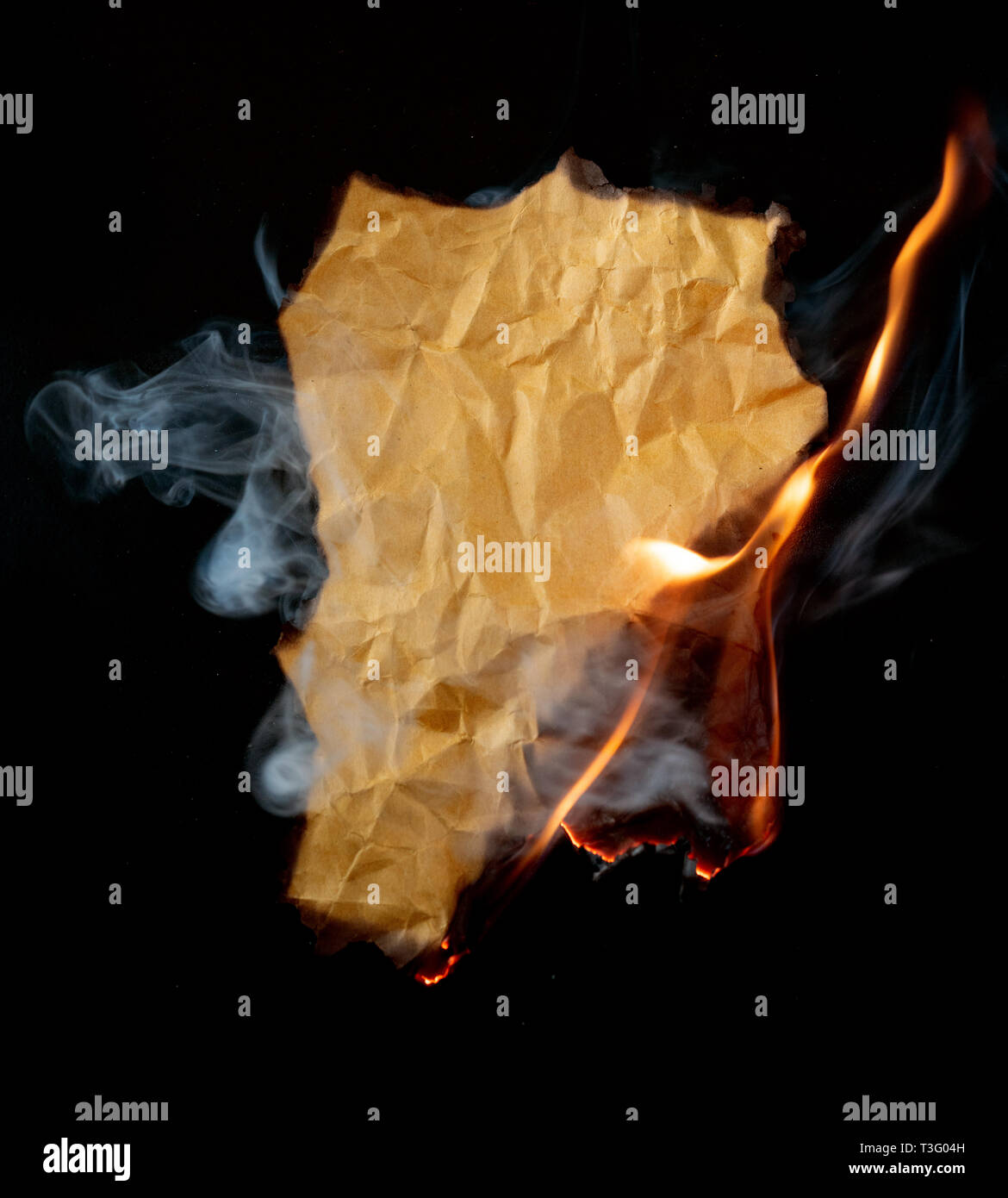 burning piece of crumpled paper on black background Stock Photo - Alamy