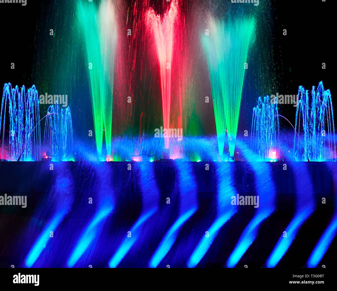 Close-up of a beautiful colorful water fountain operated at nighttime ...