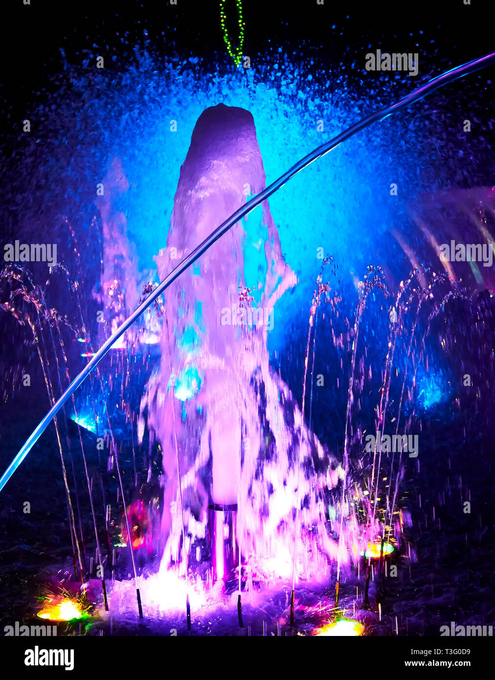 Close-up of a beautiful colorful water fountain operated at nighttime ...