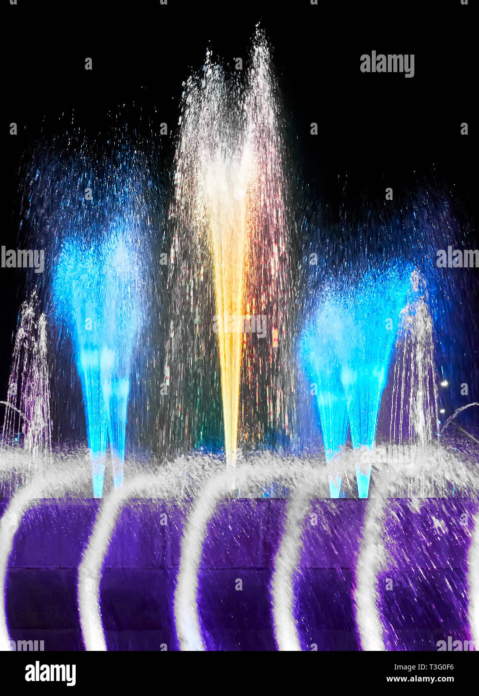 Close-up of a beautiful colorful water fountain operated at nighttime ...