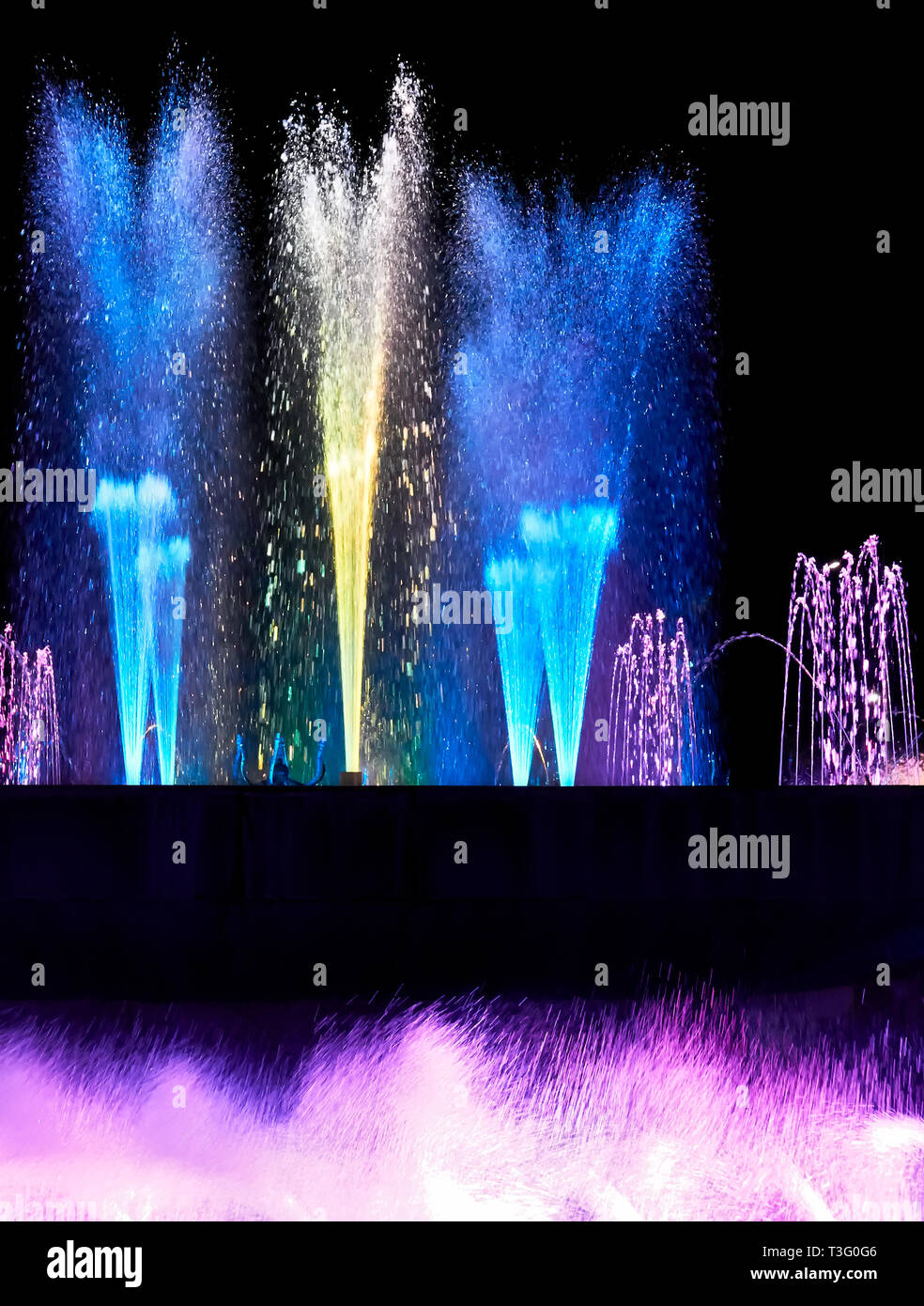 Close-up of a beautiful colorful water fountain operated at nighttime ...