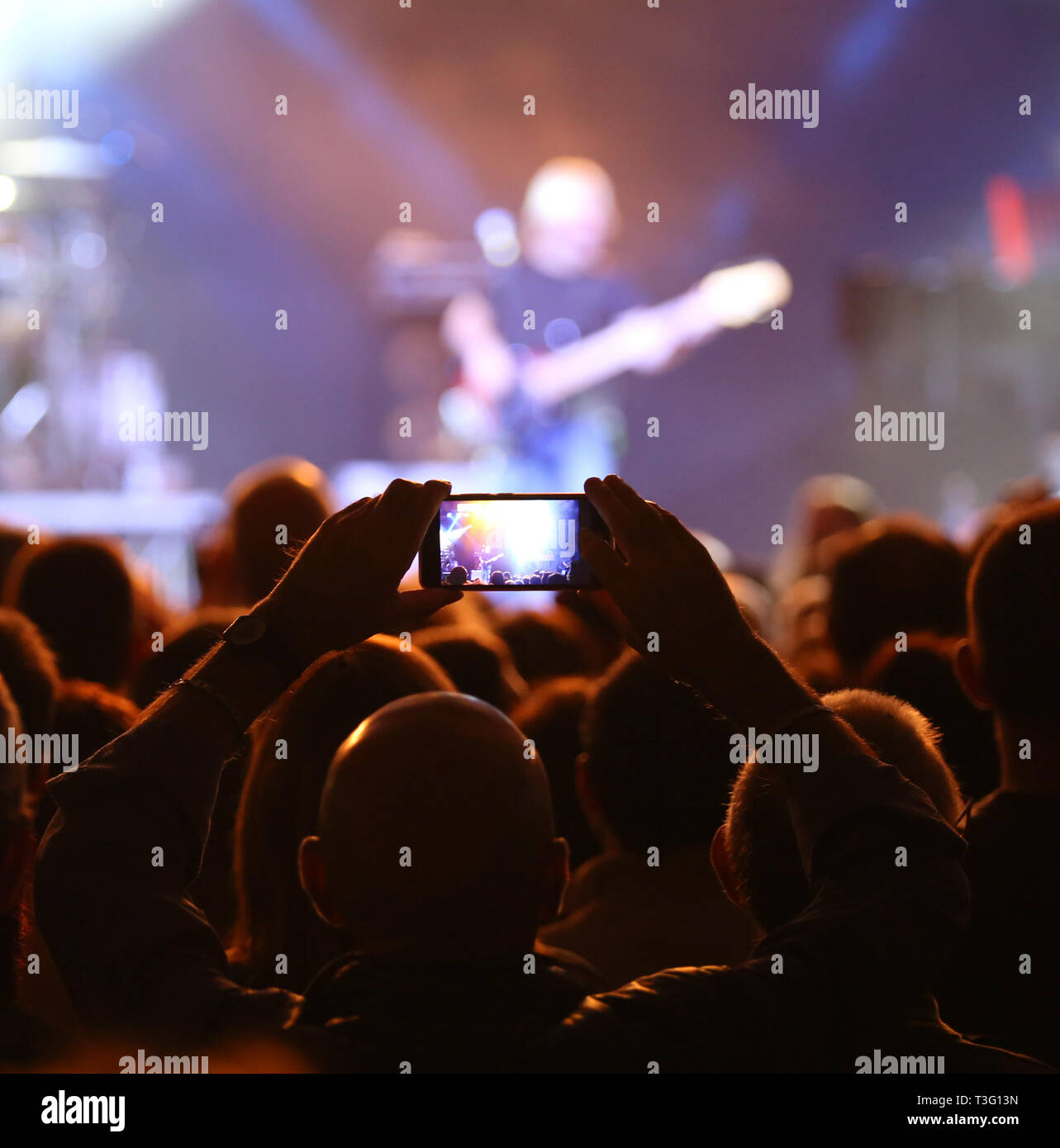 live concert with a solo guitarist and the man with smart phone Stock ...