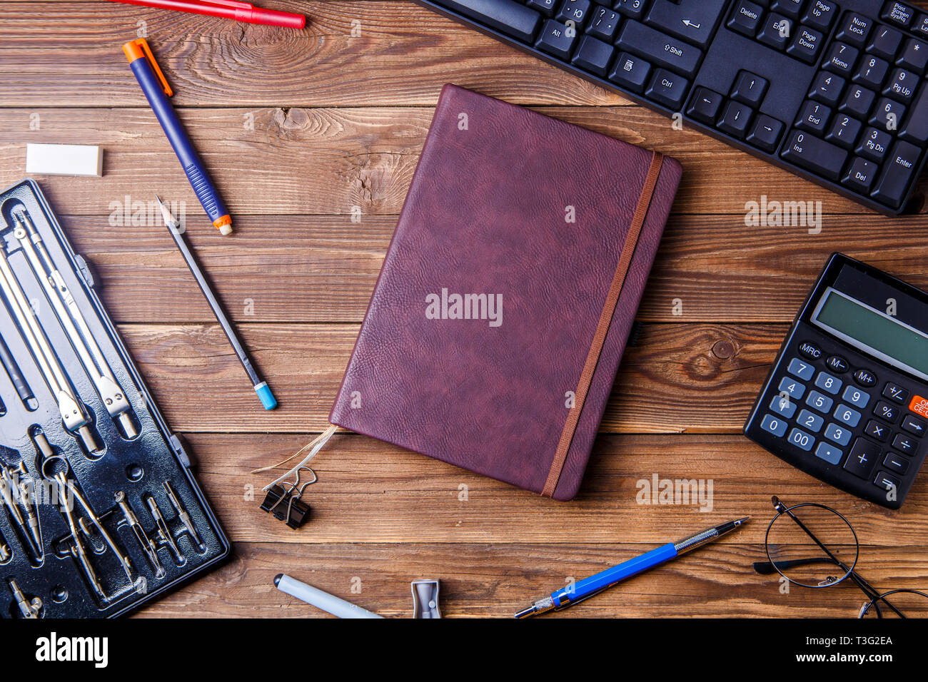 Wooden table with copybook and student material Stock Photo - Alamy
