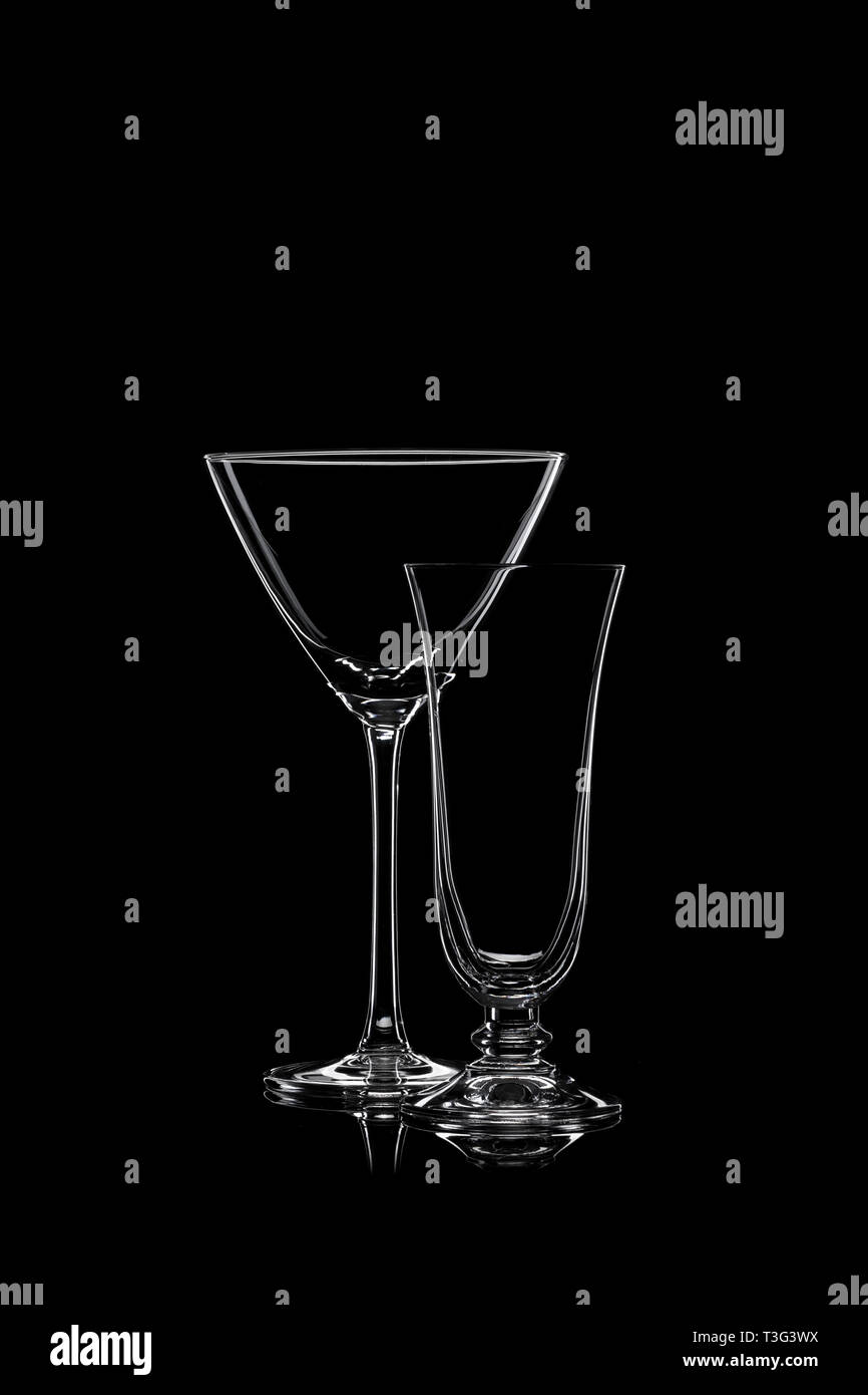 Empty cocktail glassware on a black background Stock Photo - Alamy