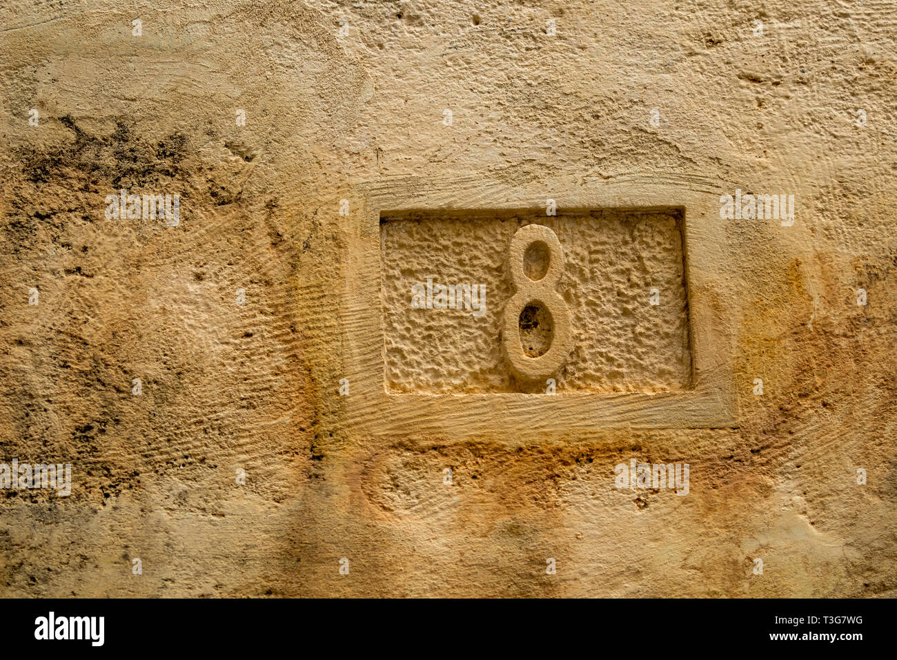 Street house number eight, 8, carved into yellow limestone, put into ...