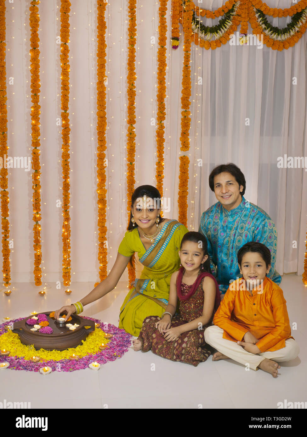 PORTRAIT OF AN INDIAN FAMILY OF FOUR CELEBRATING THE FESTIVAL OF DIWALI ...