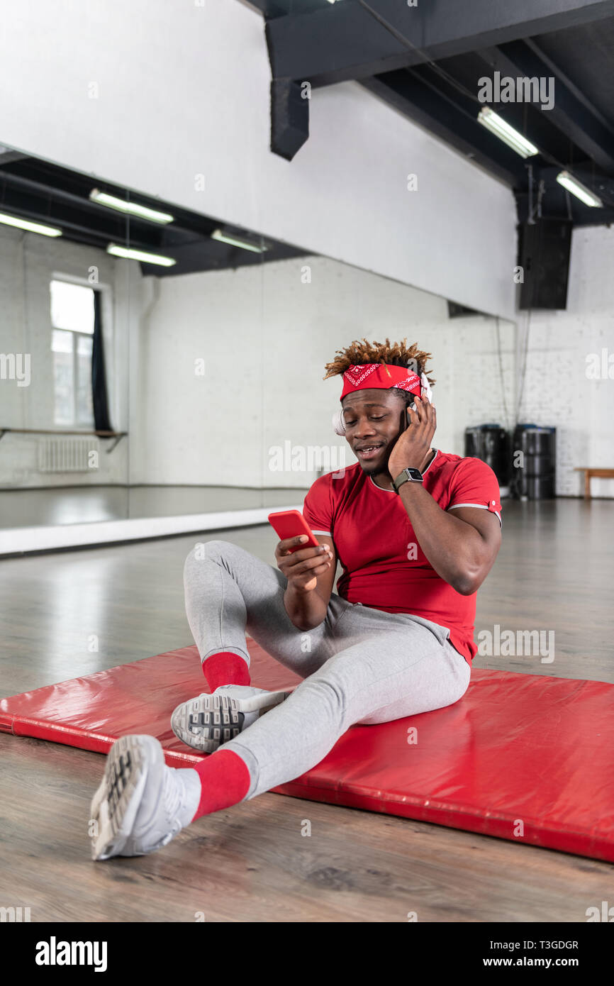 Active short-haired man being in great mood while sitting on floor ...