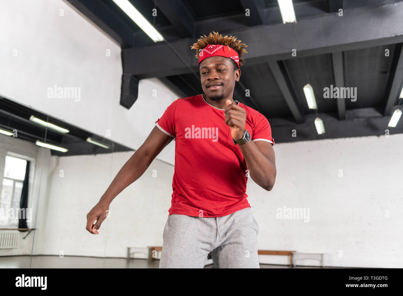 Active good-looking young dancer having routine repetition of his ...