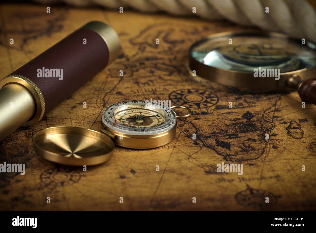 Vintage compass, spyglass and magnifying glass lies on an ancient world ...