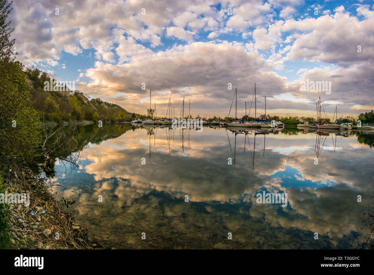 Peer featuring docks, boats, calm water and beautiful sky reflection on ...