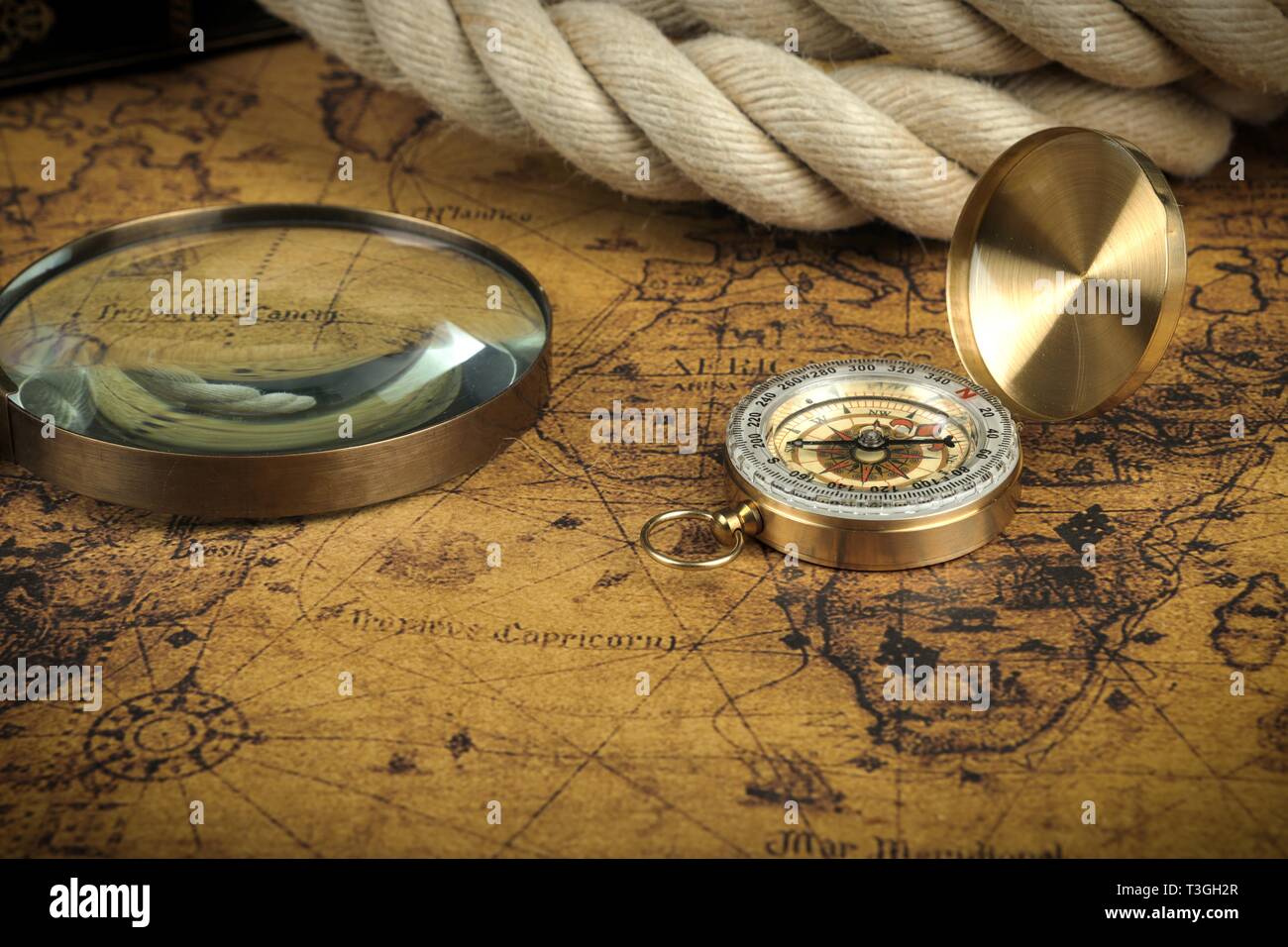 Vintage Compass and magnifying glass lies on an ancient world map ...
