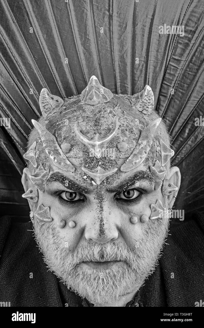 Head with thorns or warts, face covered with glitters, close up. Demon ...