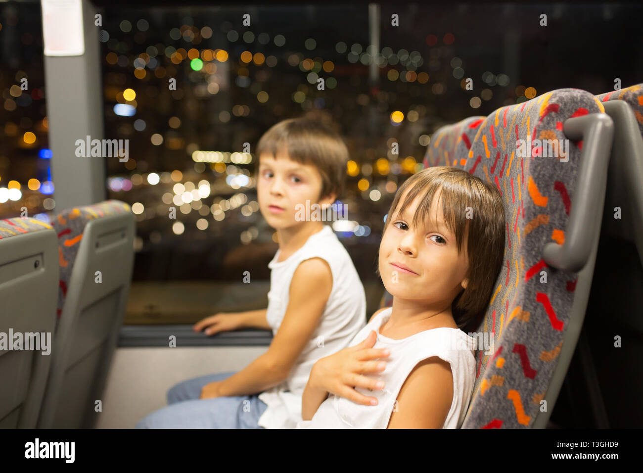 Portrait of children, boys on a bus, enjoying the night view with ...