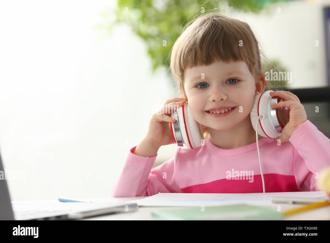 Little girl wearing headphones use mobile computer Stock Photo - Alamy