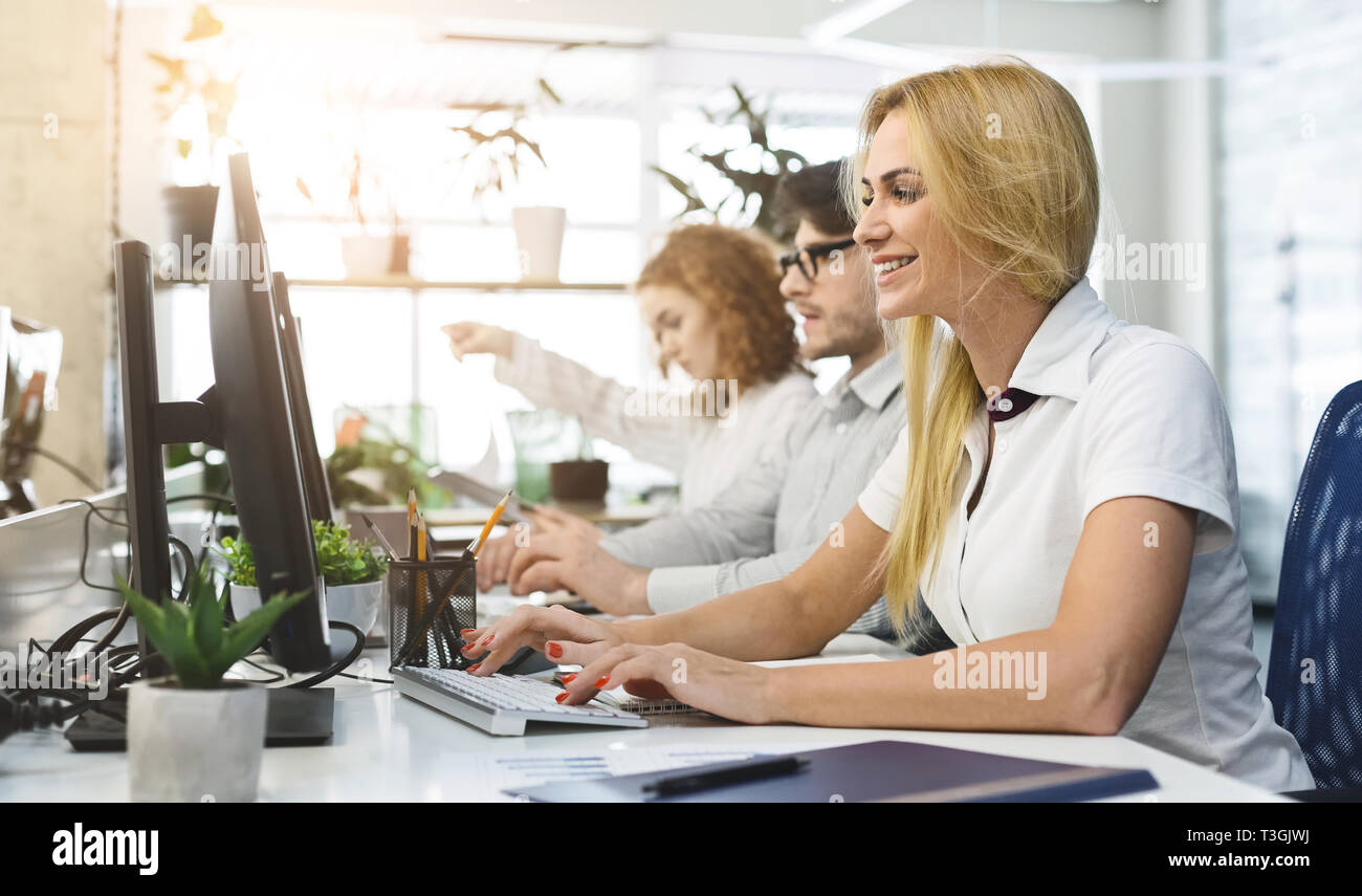 Casual business team working on computers in office Stock Photo - Alamy