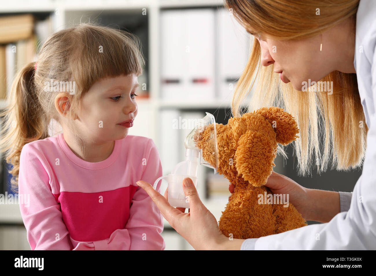 Doctor play with little patient giving inhaler to toy Stock Photo - Alamy