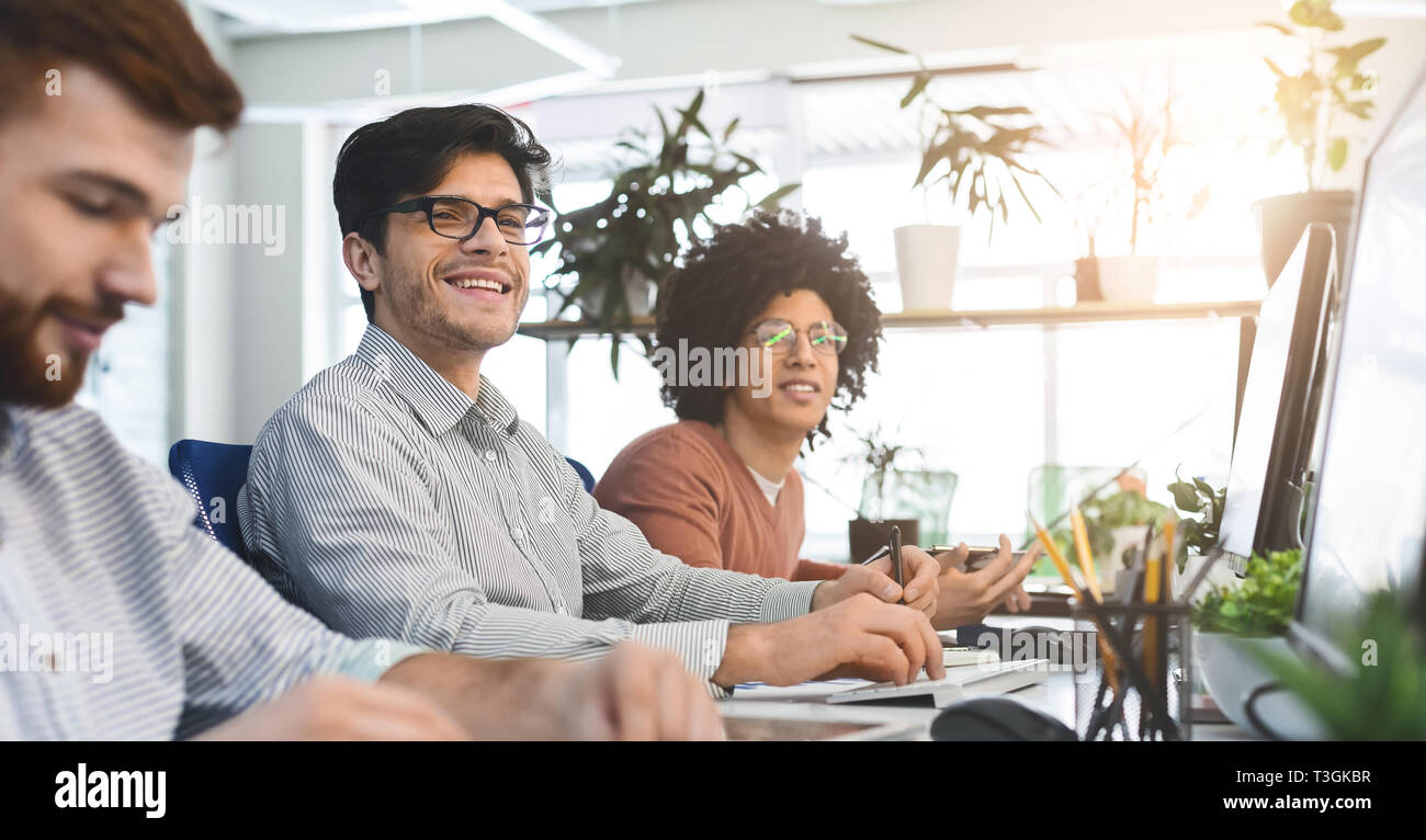 Diverse men sitting at workplace in office Stock Photo - Alamy