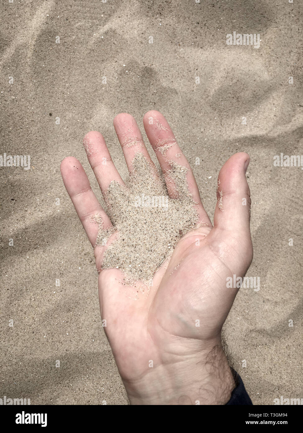 Man having sand in his open hand Stock Photo - Alamy