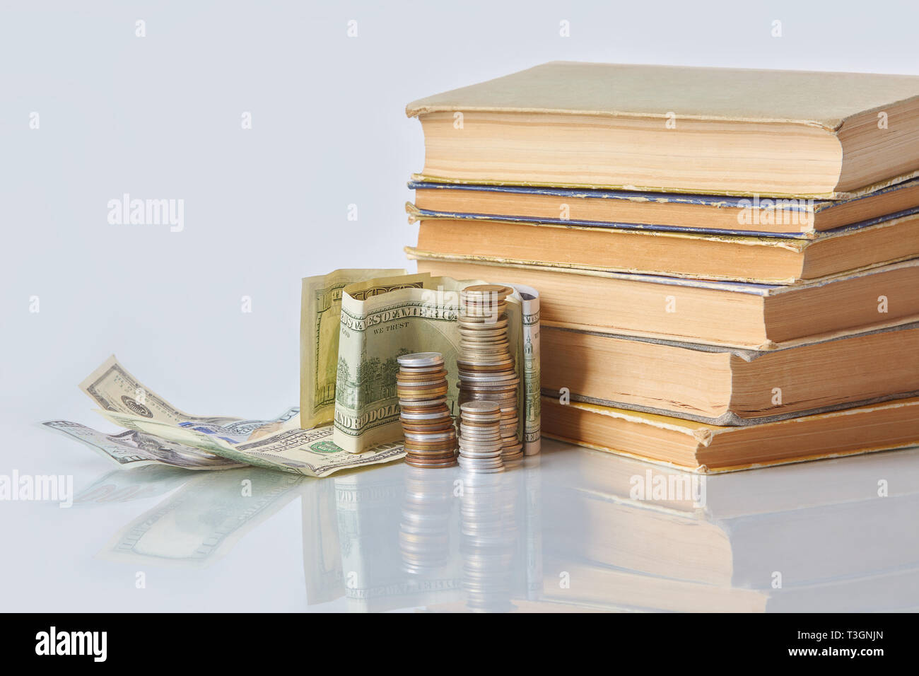 Financial education concept - money: bills, coins, old books on a glass ...
