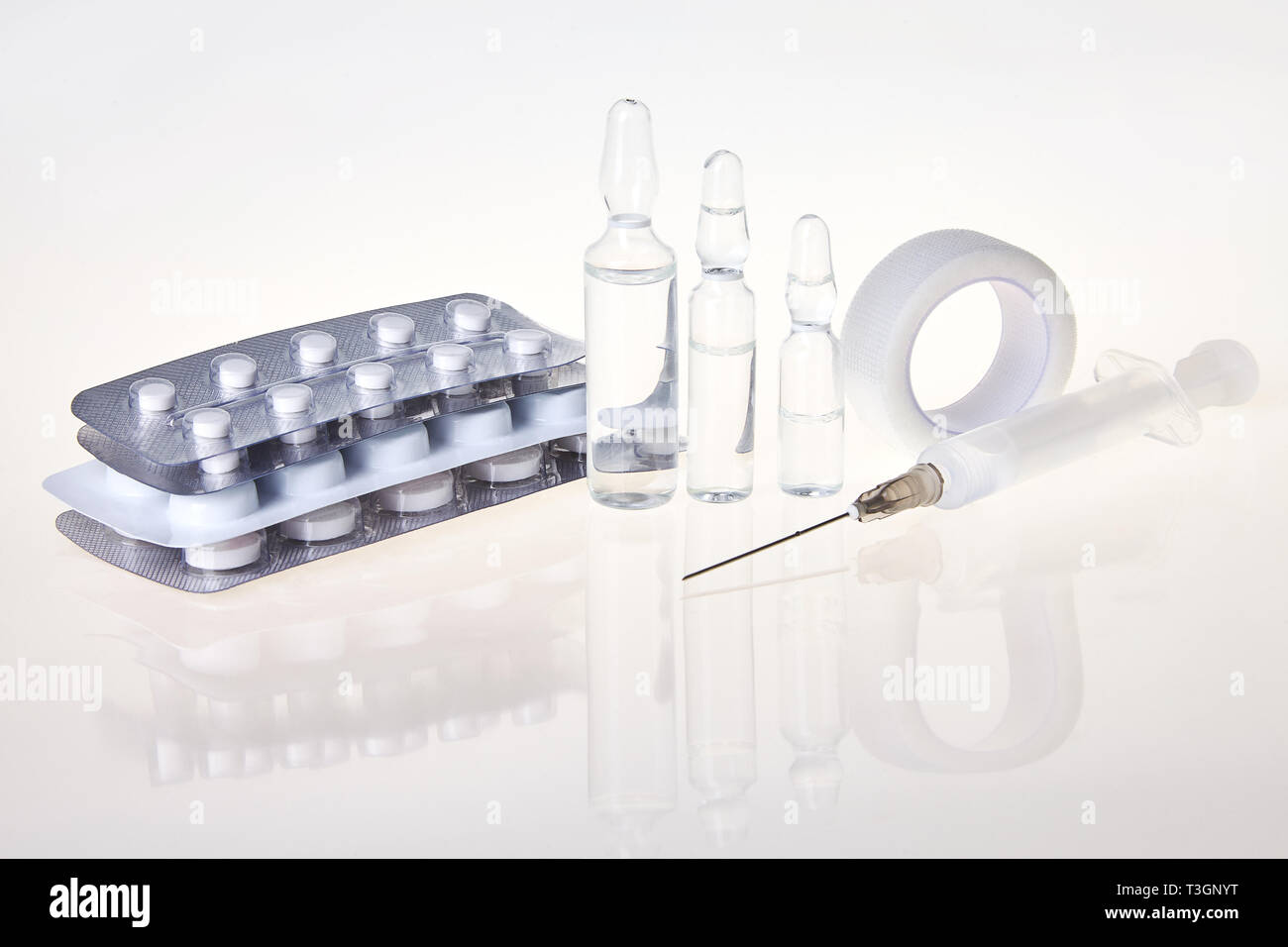 Tablets, medical ampoules and syringe injection on mirror background ...