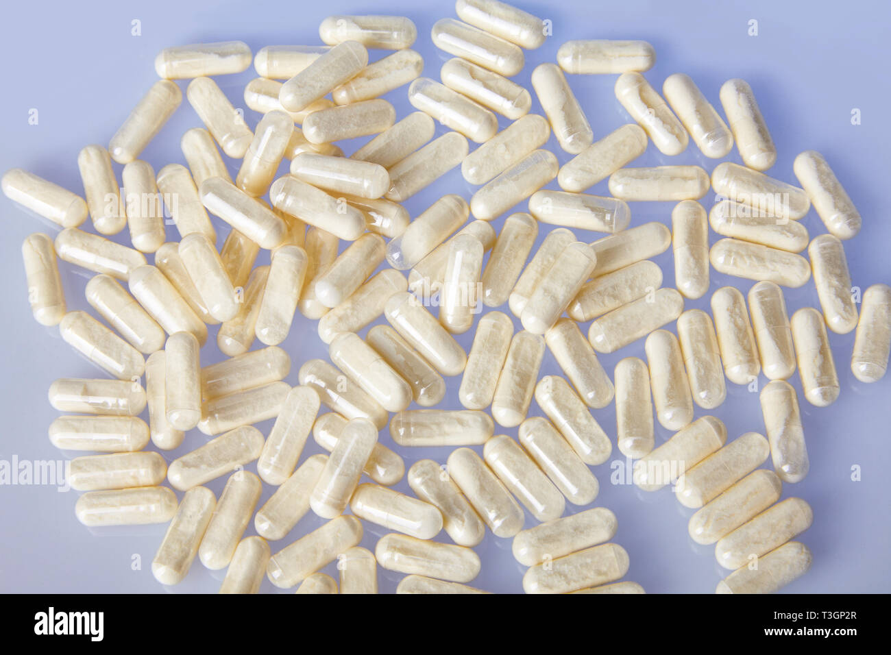 Lots of colorful drugs and pills on blue mirror background. Scattered ...