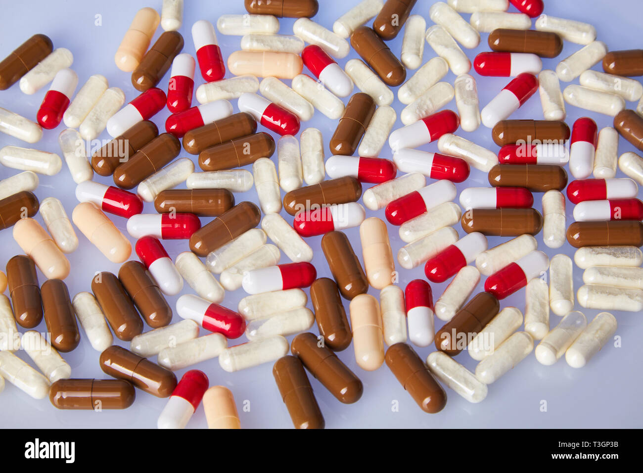 Lots of colorful drugs and pills on blue mirror background. Scattered ...