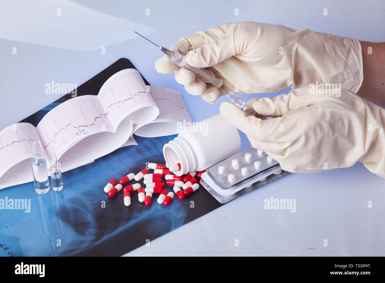 Scattered capsules, tablets, ampoules on the table with cardiogram ...