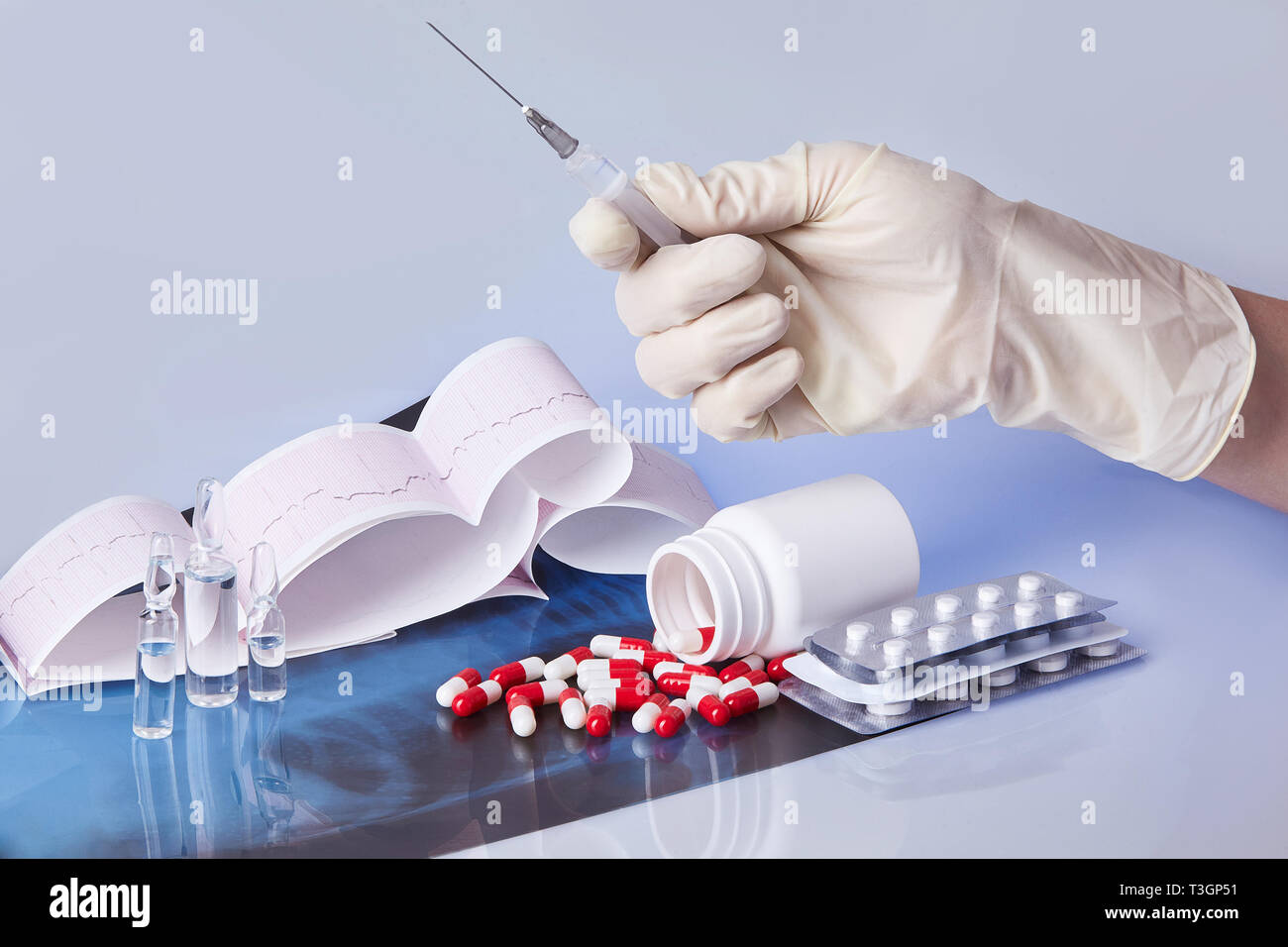 Scattered capsules, tablets, ampoules on the table with cardiogram ...