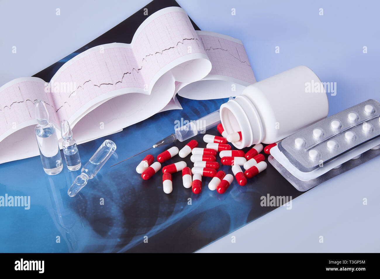 Scattered capsules, tablets, ampules and syringe on the table with ...