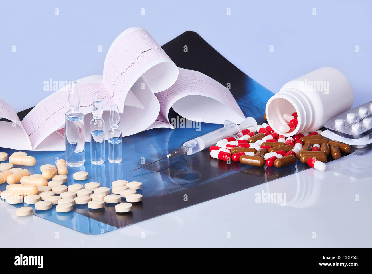 Scattered capsules, tablets, ampules and syringe on the table with ...