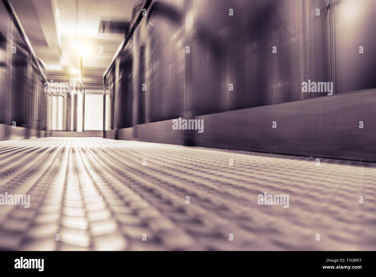 Metal floor in the factory between large metal barrels. Motion blur ...
