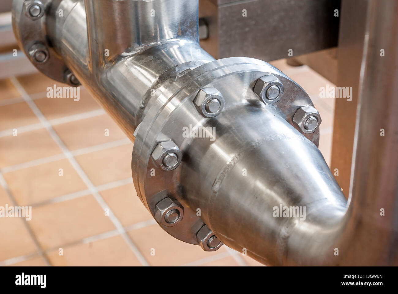 Connection of stainless steel pipes with bolts. Brilliant surfaces ...