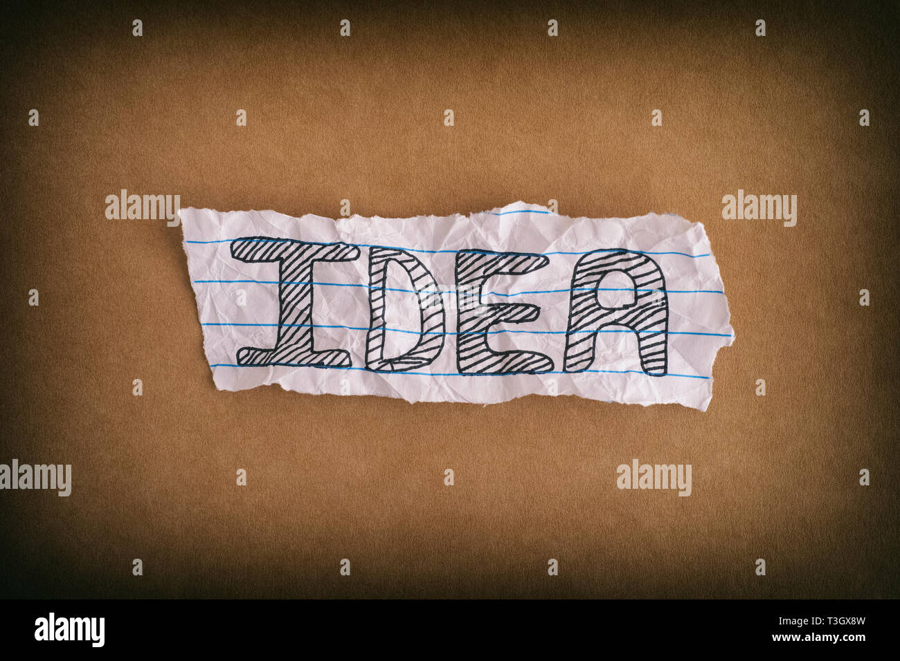 Idea. Crumpled piece of paper with the word Idea on brown paper ...