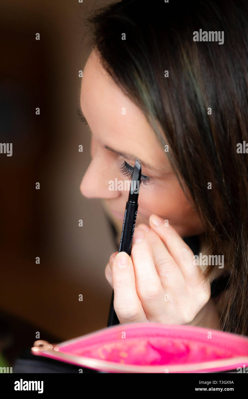 Caucasian Women applying make-up before going out Stock Photo - Alamy