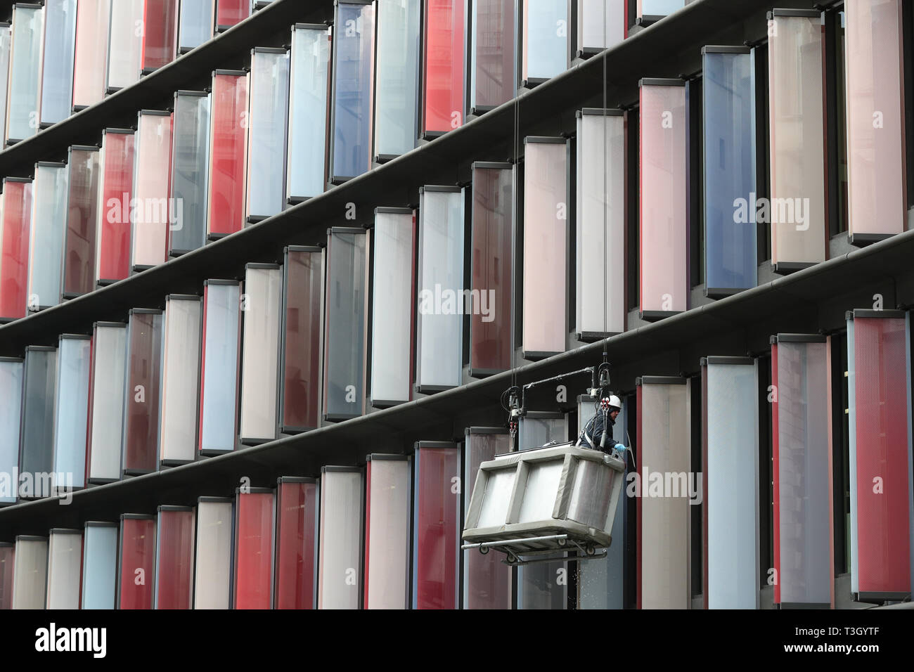 Window cleaners in a hoist at work on the exterior of Mizuho House, Old ...