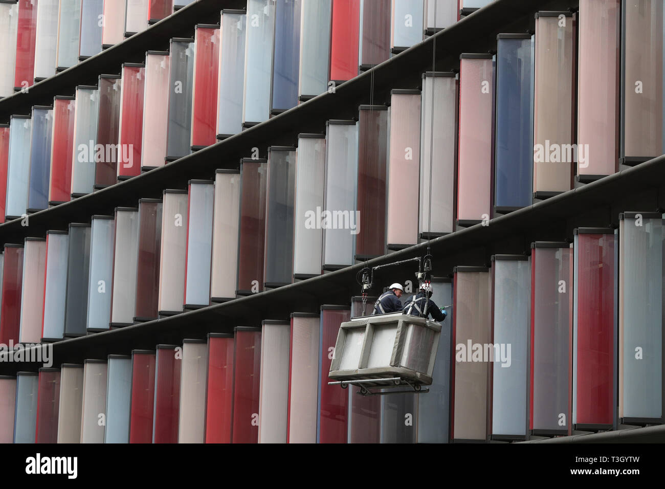 Window cleaners in a hoist at work on the exterior of Mizuho House, Old ...