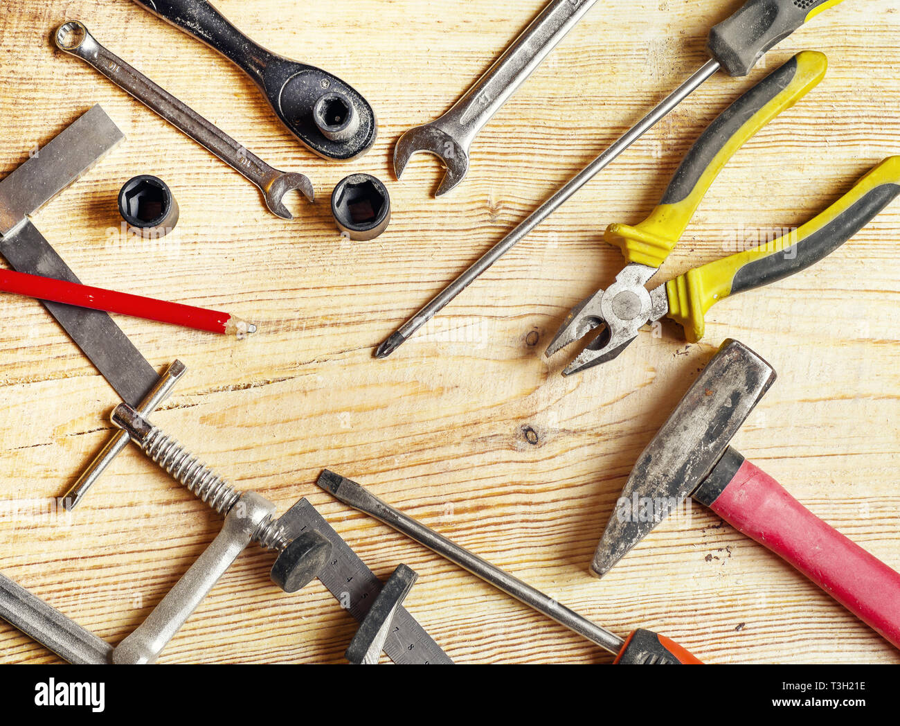 Tools spread out on the board, screwdrivers, pliers, wrenches, squares ...