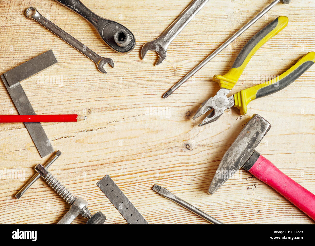 Tools spread out on the board, screwdrivers, pliers, wrenches, squares ...
