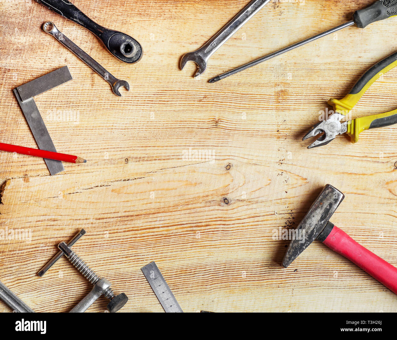 Tools spread out on the board, screwdrivers, pliers, wrenches, squares ...