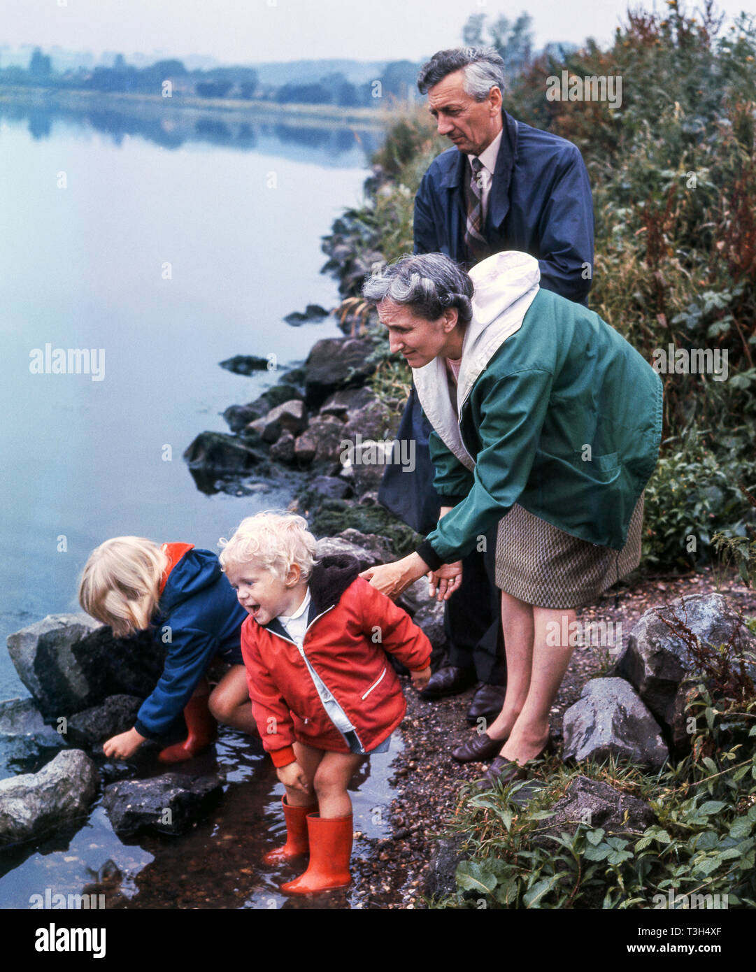 Two young children,with their grandparents,are intrigued by the river ...