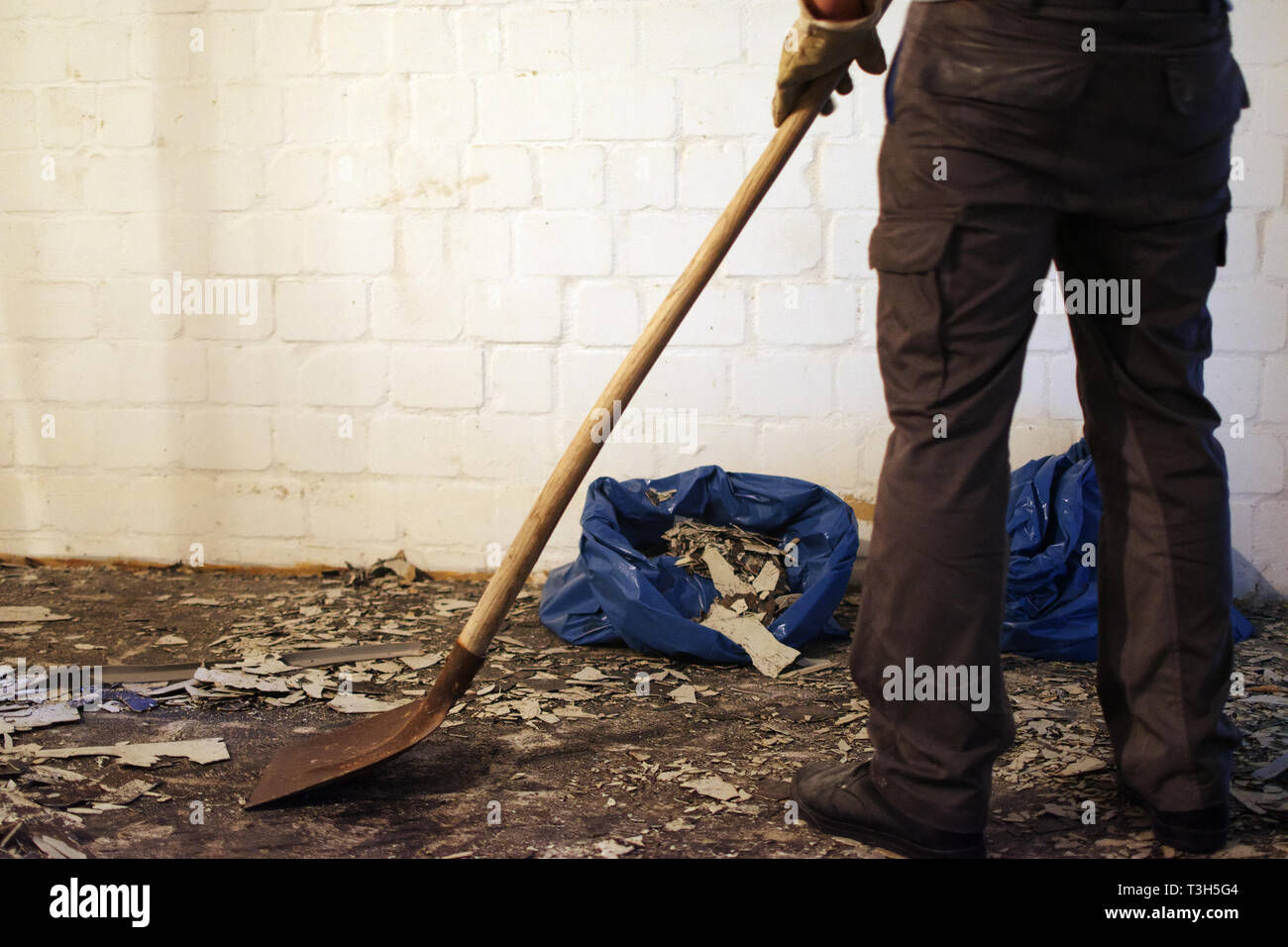 Man collects debris with shovel Stock Photo - Alamy
