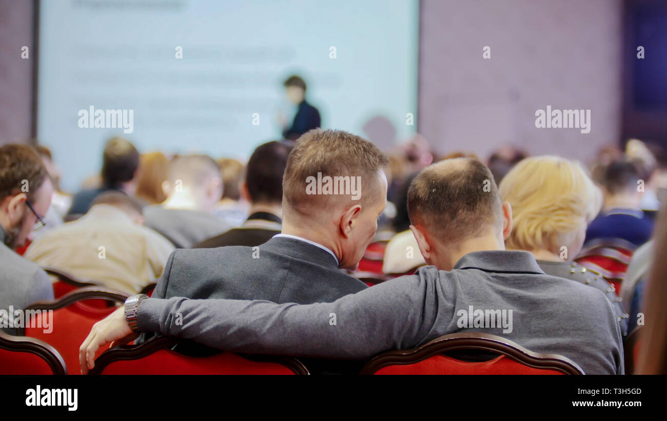 A business conference. People sitting in the hall and watching the ...