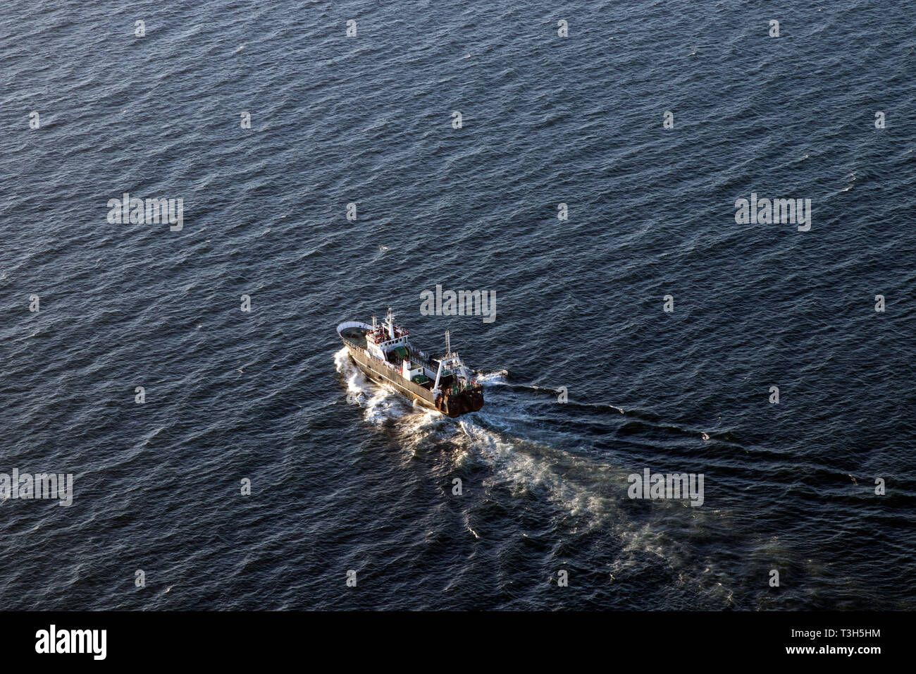 A large tug boat or small ship sailing on the coast of south africa ...