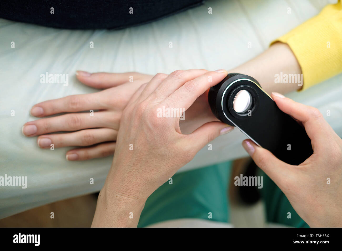 Female Dermatologist Using A Professional Dermatoscope While Doing Skin