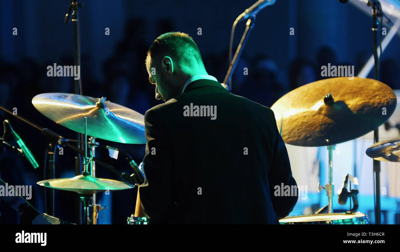 A calm musician man in costume playing drums at the jazz concert Stock ...