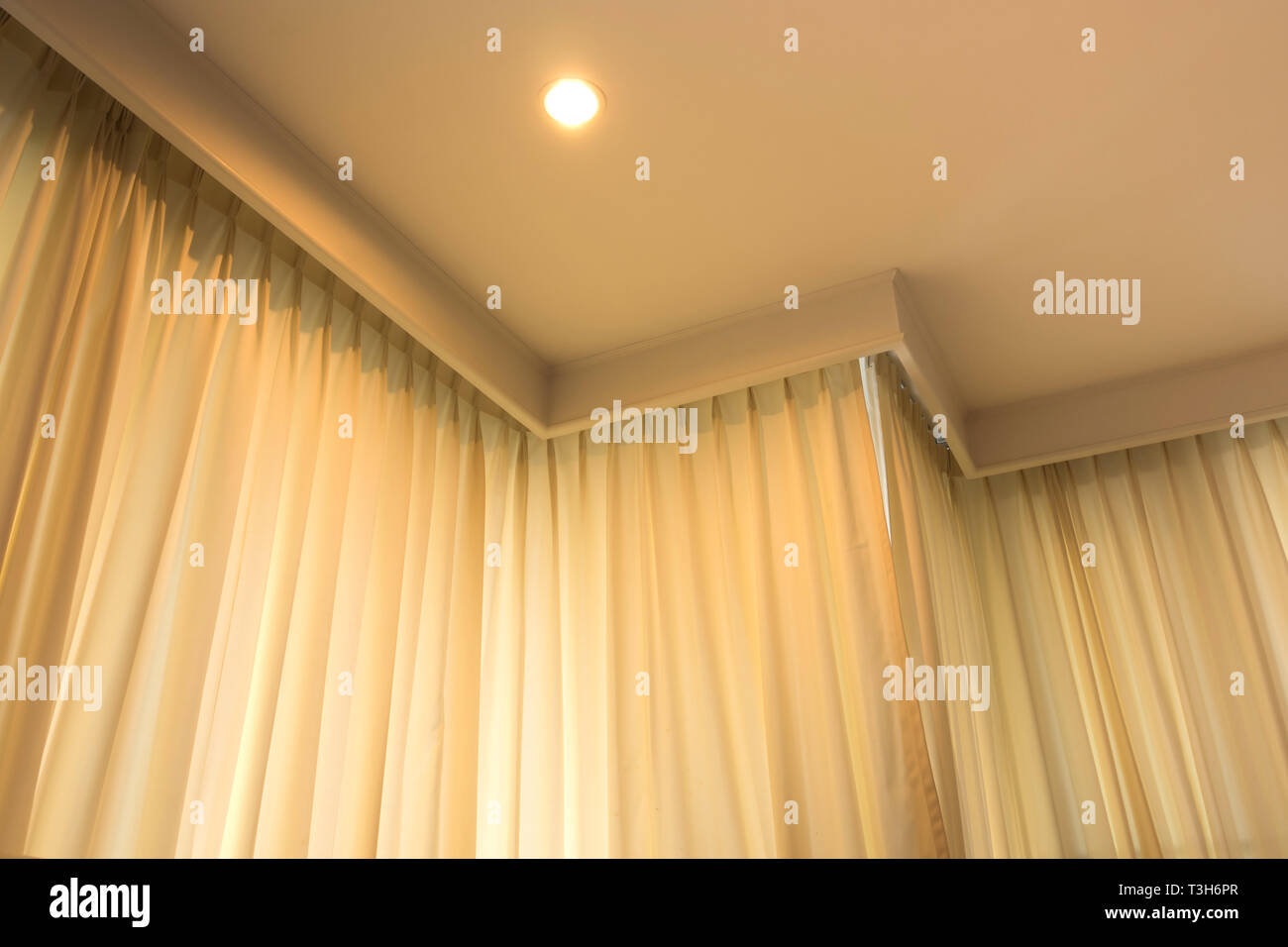 Light from Ceiling lamp and light from nature behind fabric curtain ...