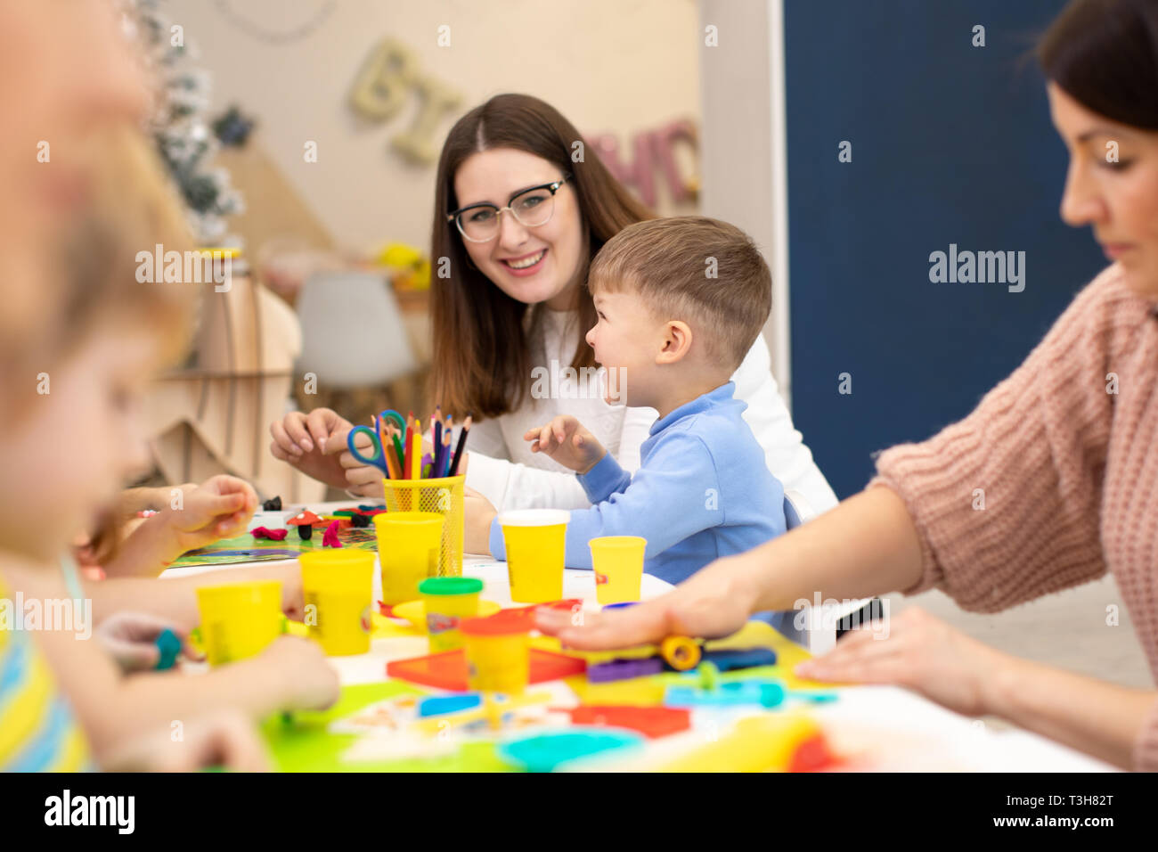 Preschool kids sticking with plasticine in classroom in kindergarten ...