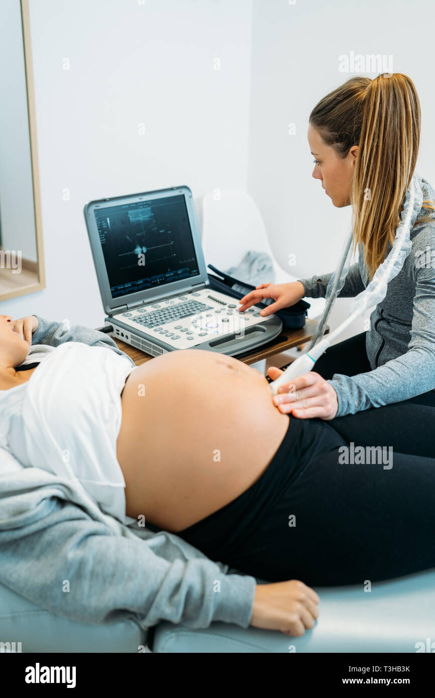 Doctor performing an ultrasound scan on pregnant woman Stock Photo - Alamy