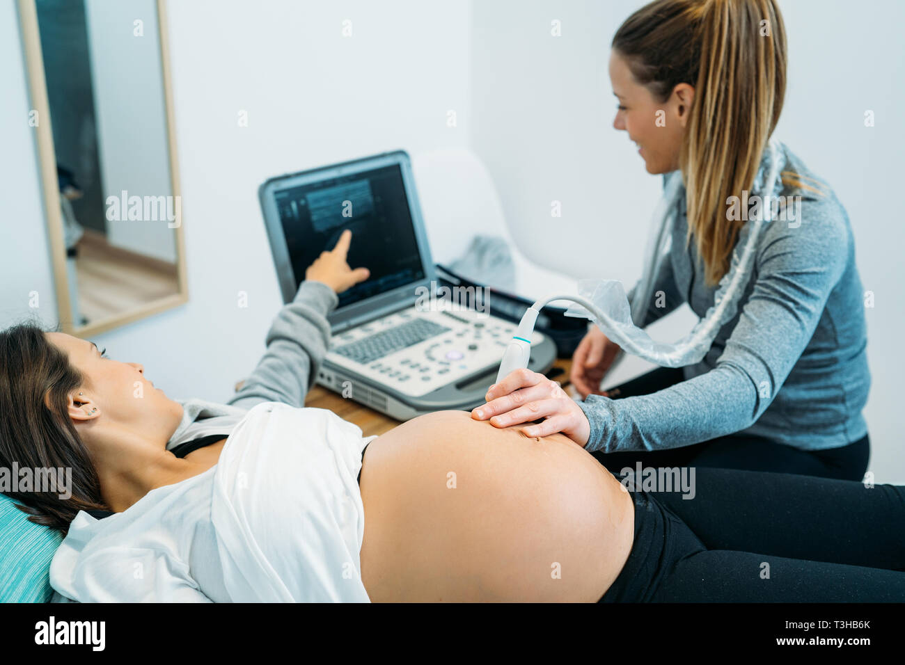 Doctor performing an ultrasound scan on pregnant woman Stock Photo - Alamy