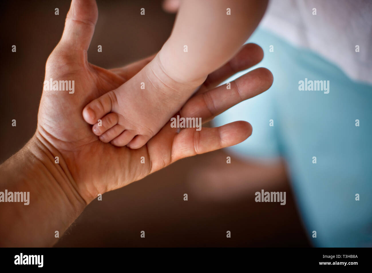 Baby's foot in hand Stock Photo - Alamy